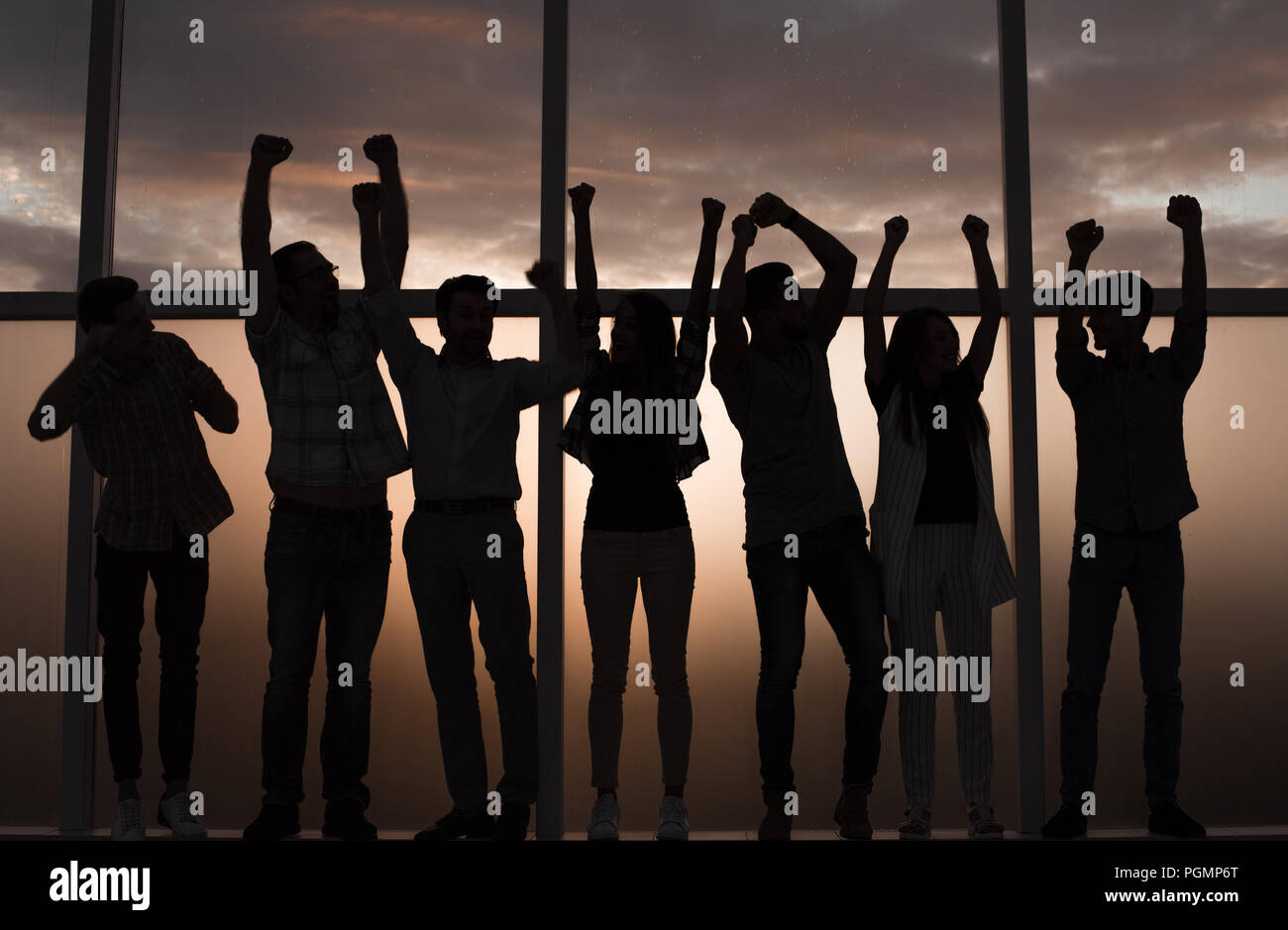 business team standing near the window with hands up Stock Photo - Alamy