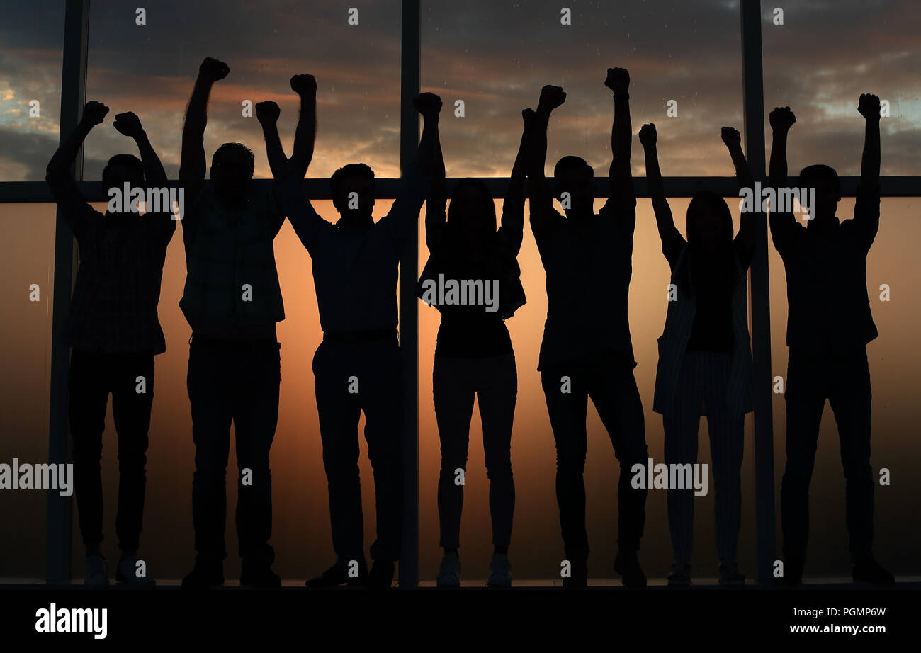 business team standing near the window with hands up Stock Photo - Alamy