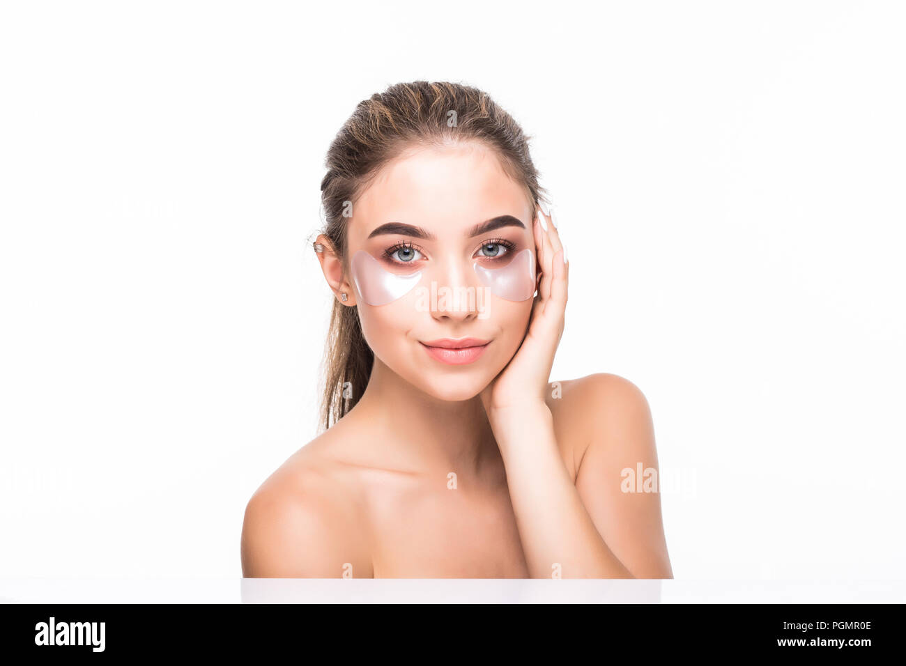 Woman cleaning her face. Beautiful young woman with clear-up patches or ...