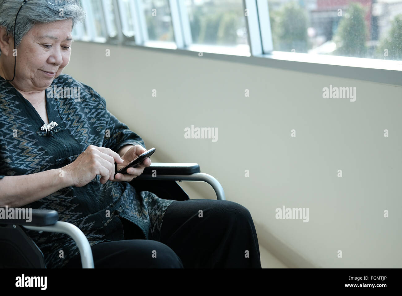 elder woman in wheelchair holding mobile phone. elderly senior female ...