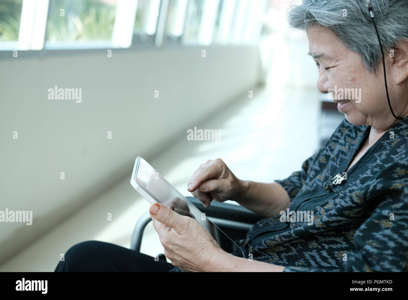 elder senior woman in wheelchair holding tablet. elderly female texting ...