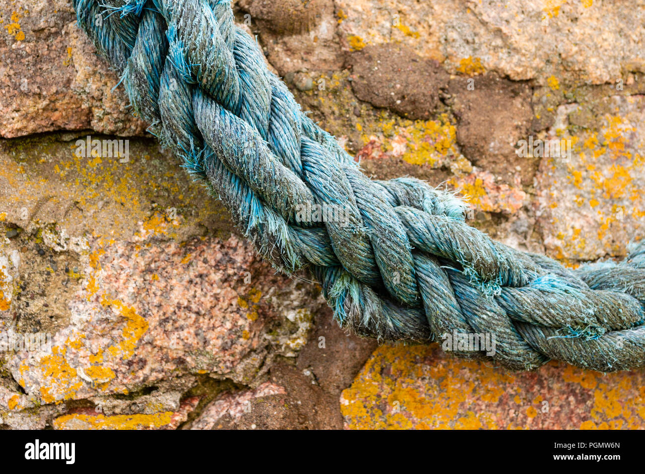Old, frayed polypropylene rope against a stone wall Stock Photo - Alamy