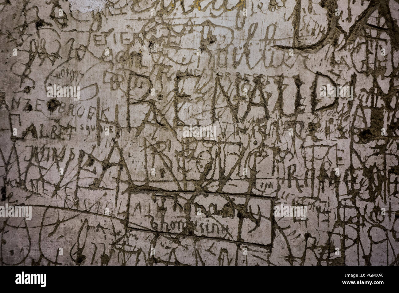 Old graffiti and scratchwork on wall inside the medieval Château de ...