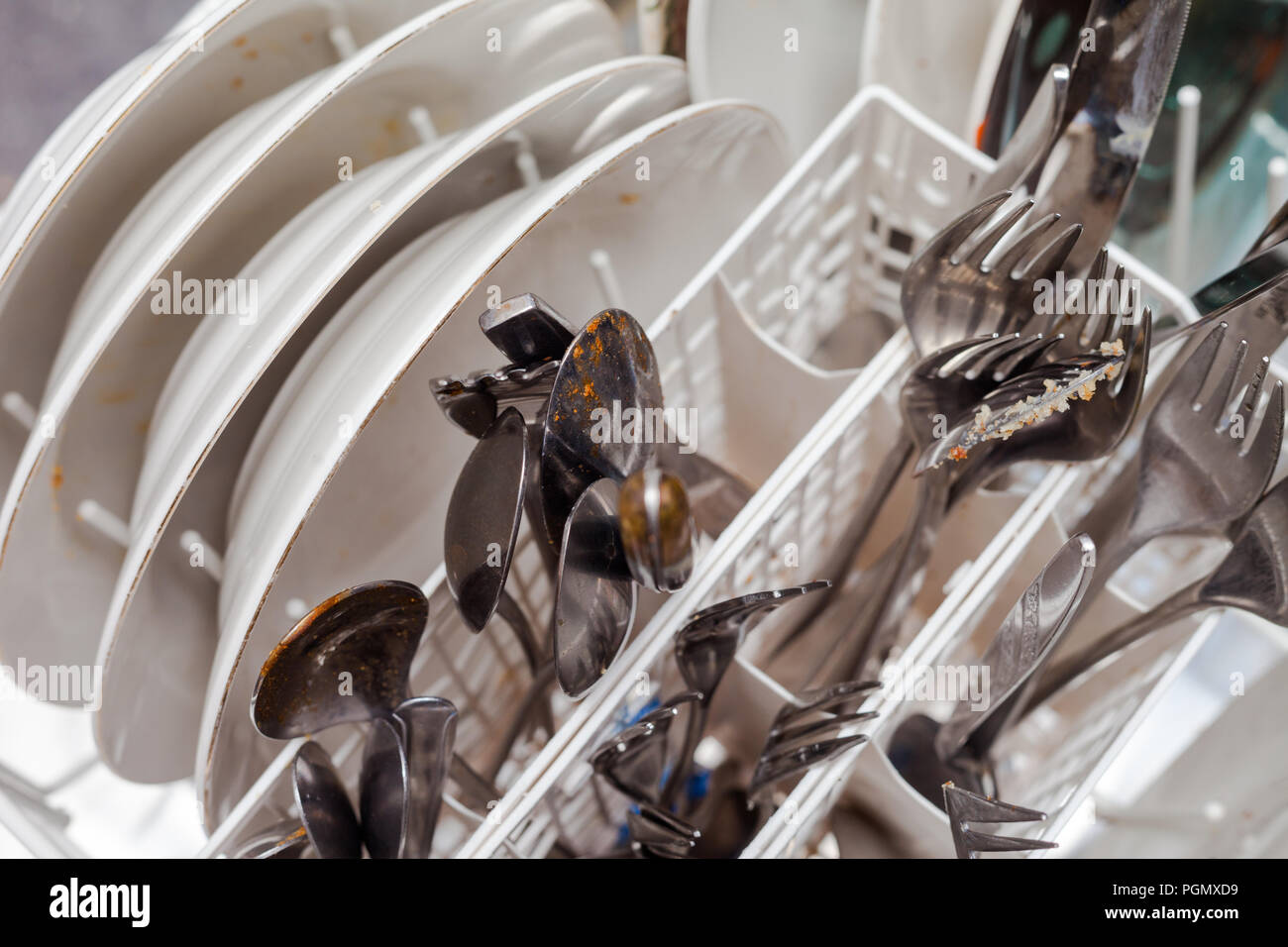Dishwasher drawer filled with dirty or soiled dishes, plates and ...