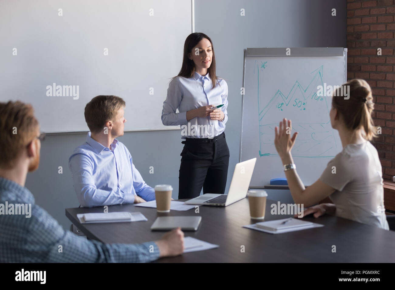 Female employee asking question to business speaker during metin Stock ...