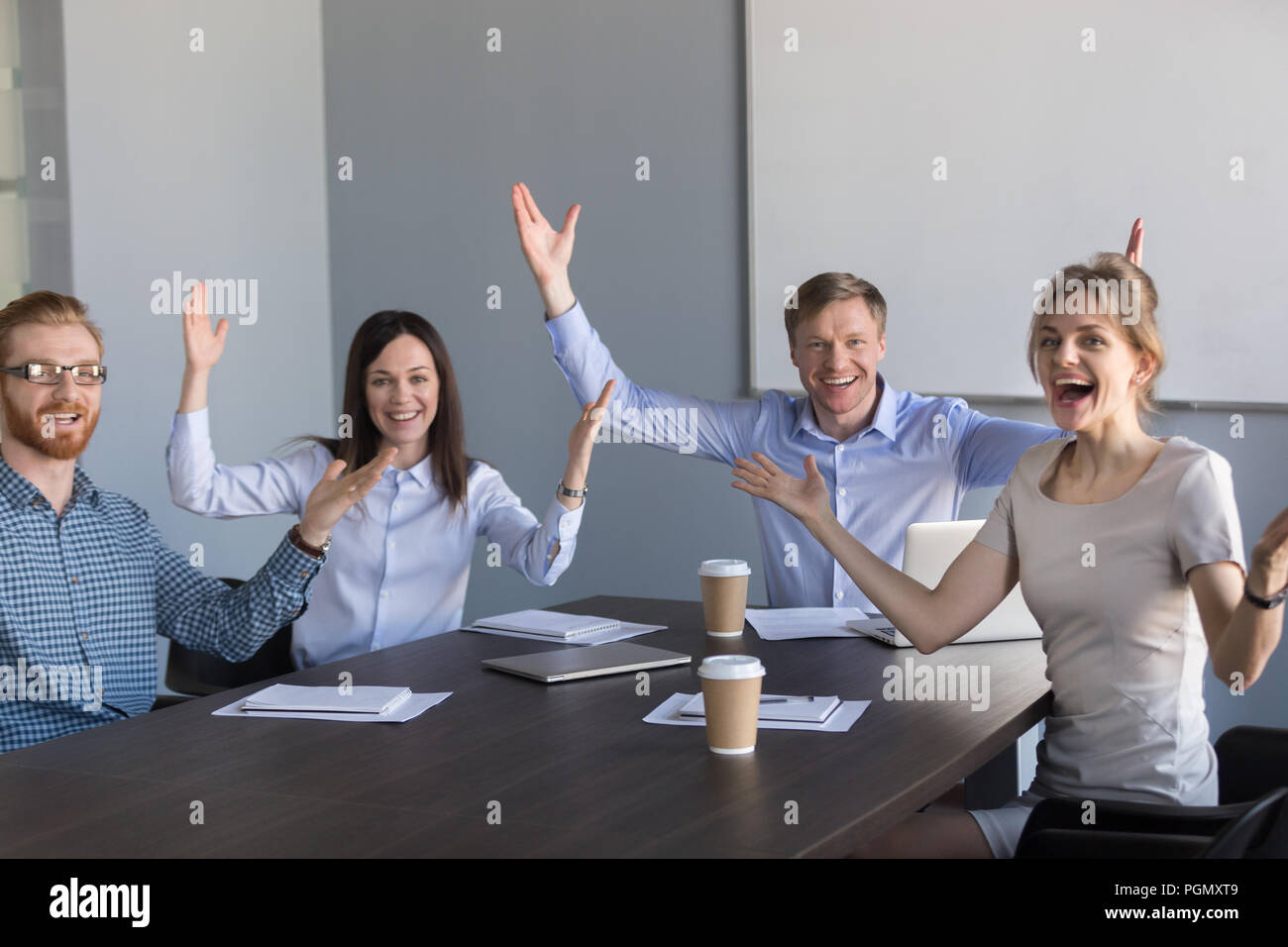 Portrait of excited colleagues raise hands up happy with success Stock ...