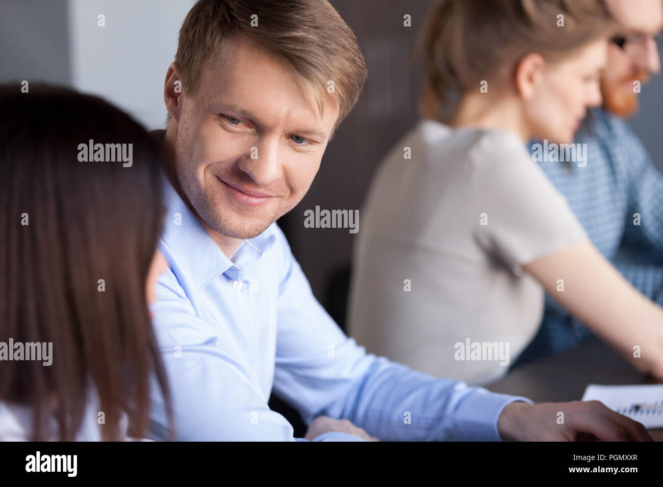 Smiling male employee listening to female colleague while cowork Stock ...