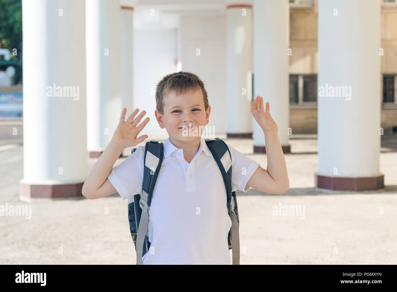 the boy is a first-grader in a white t-shirt with a gray backpack ...