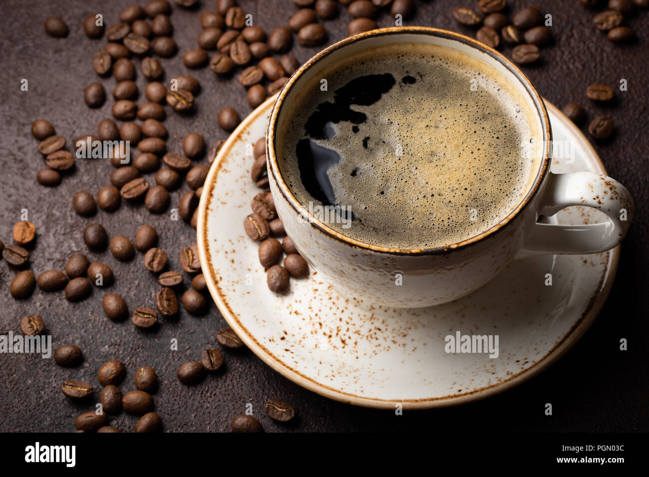 Close-up of a Cup of black coffee and coffee beans on a dark background ...