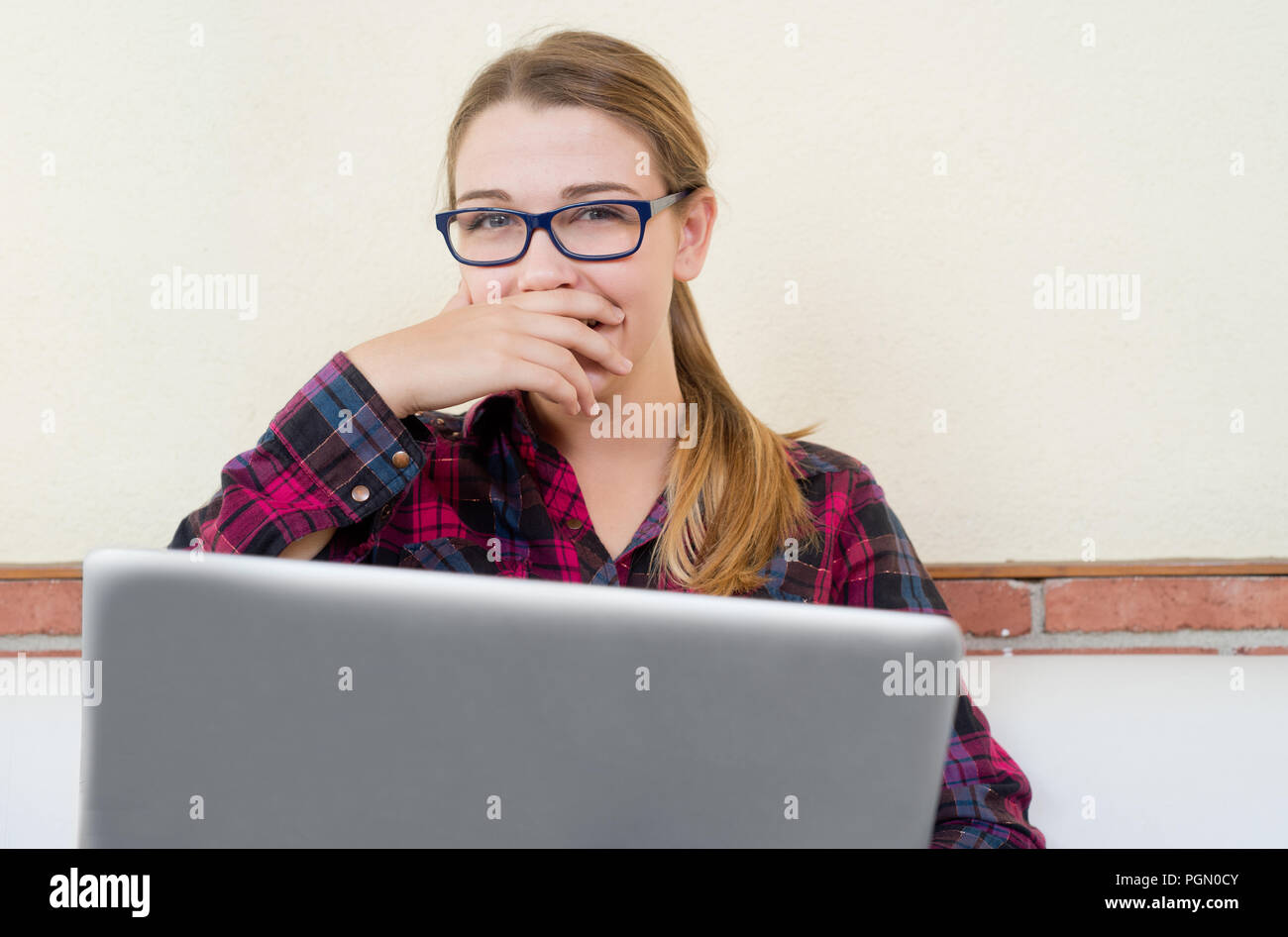 young girl with broad laughs covering the mouth Stock Photo - Alamy