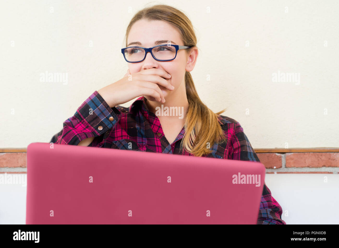 young girl with broad laughs covering the mouth Stock Photo - Alamy