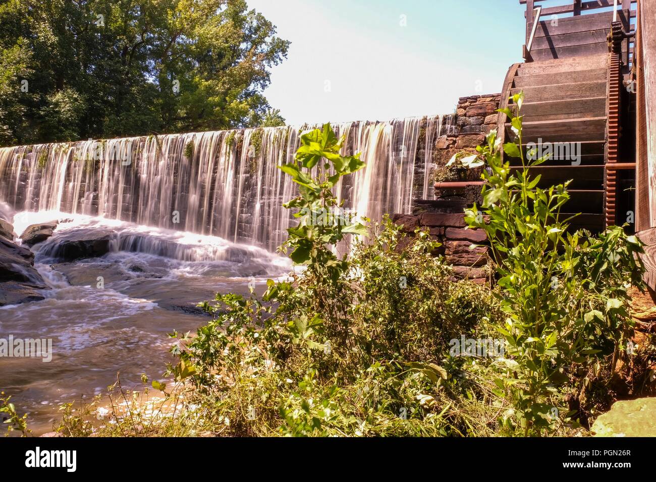 View of the waterfall and the front of the waterwheel at Historic Yates ...