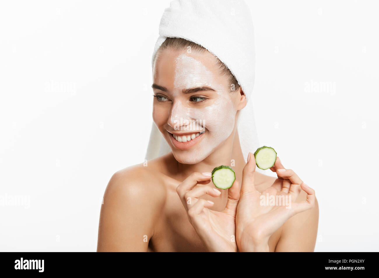 Young woman with clay facial mask holding cucumber slices isolated on white background Stock ...
