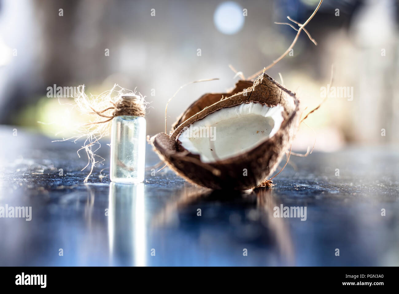 Close up of raw organic coconut or Cocos nucifera with its essence in a ...