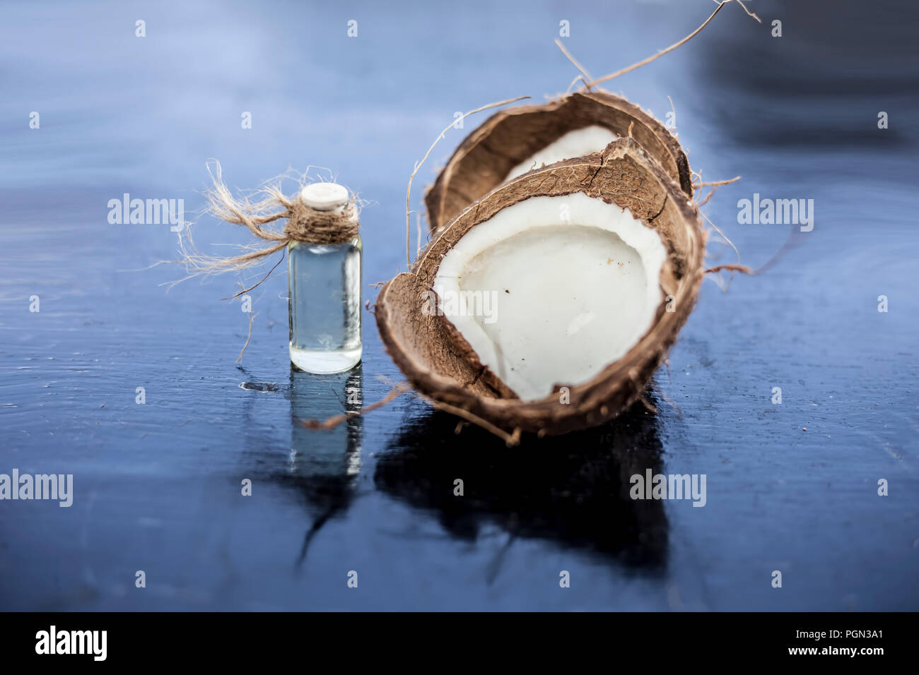 Close up of raw organic coconut or Cocos nucifera with its essence in a ...