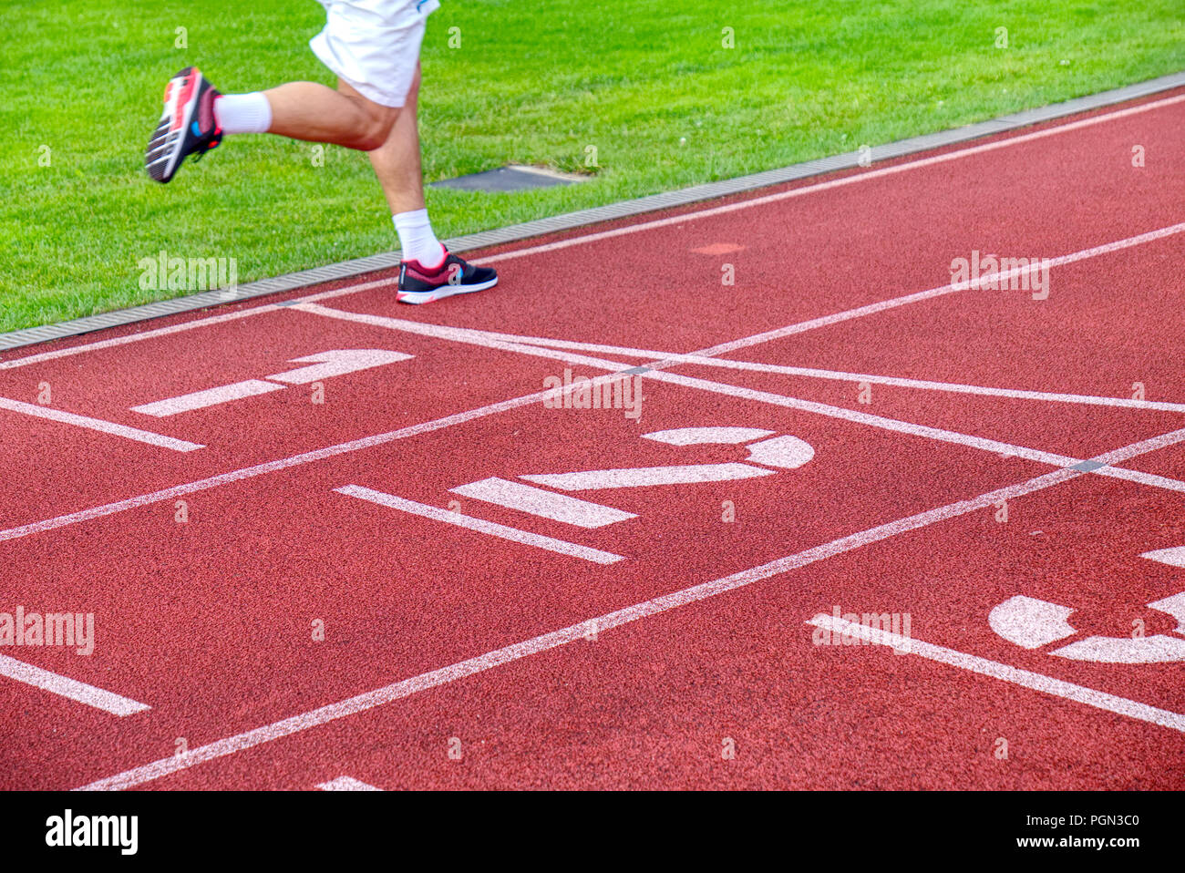 Running legs and moving shadow of a male athlete running on track of ...