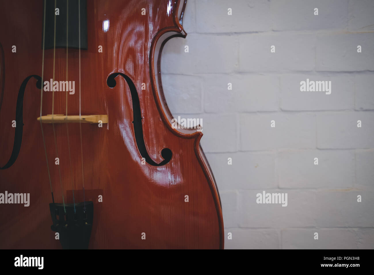 brown cello near red wall. musical instrument Stock Photo - Alamy