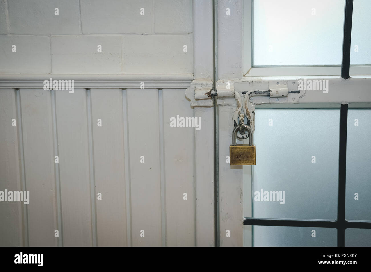 brass padlock. master key lock on white glass door. safety & security ...