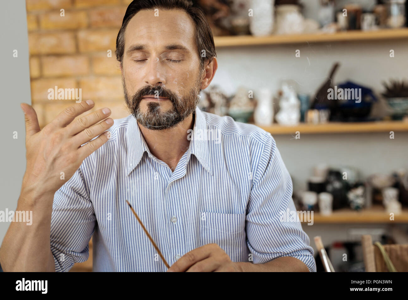 Bearded handsome man enjoying the smell of aroma candles Stock Photo ...