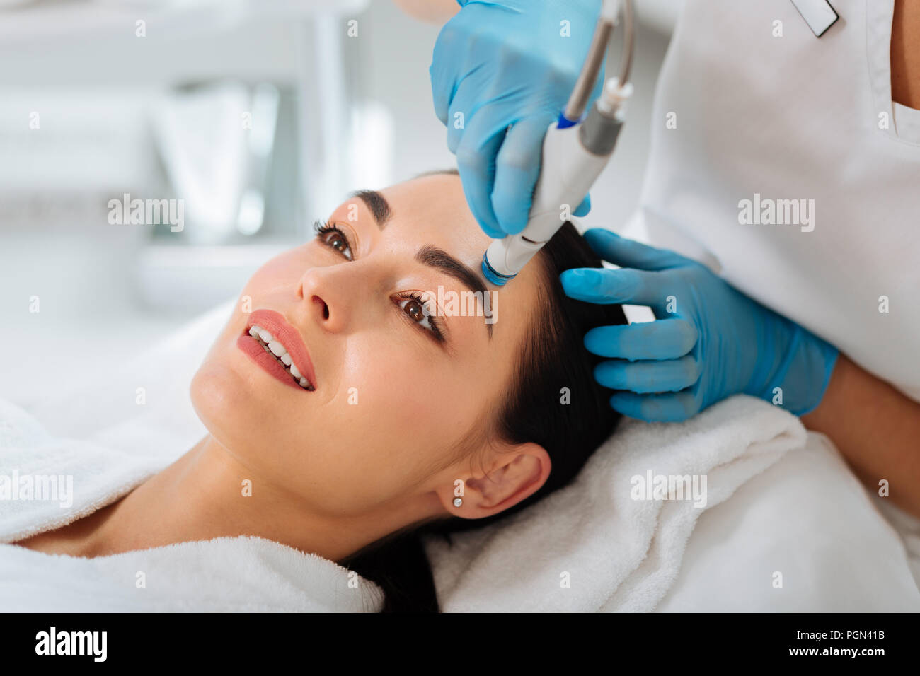 Delighted nice woman enjoying the hydrafacial procedure Stock Photo - Alamy