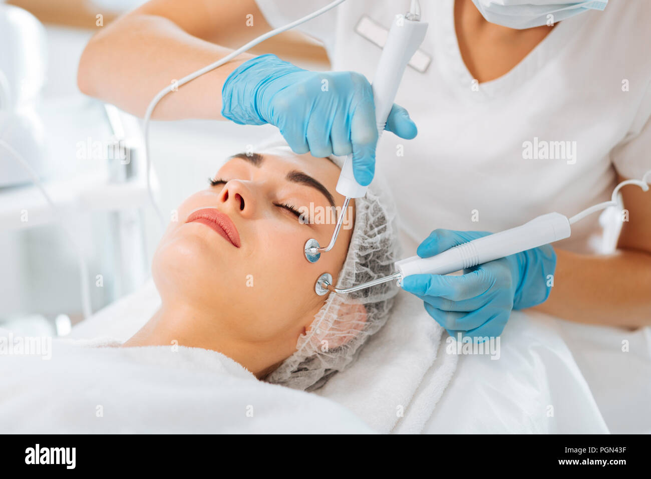 Beautiful nice young woman trying microcurrent therapy Stock Photo - Alamy