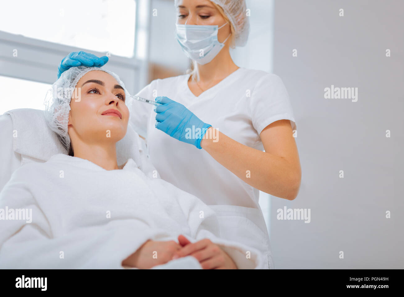 Serious nice female beautician focusing on her work Stock Photo - Alamy
