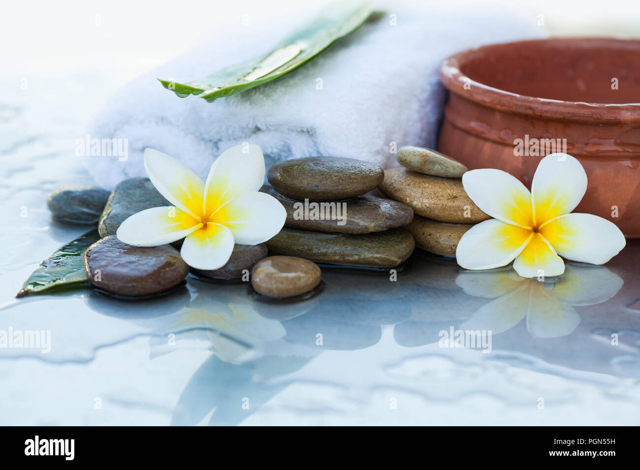 spa objects with towel and stones for massage treatment on white ...