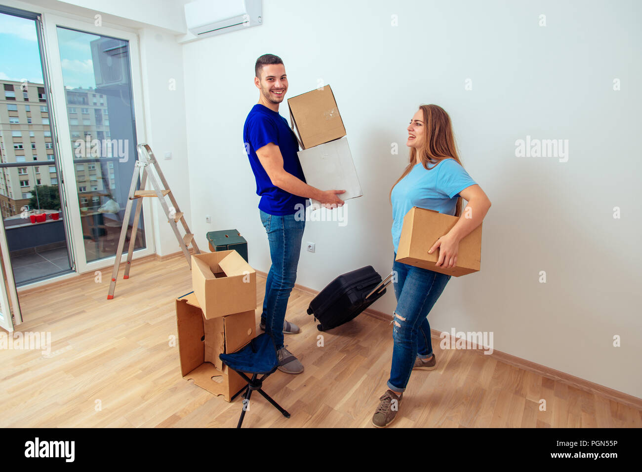 Young couple with moving boxes in room at new home Stock Photo - Alamy