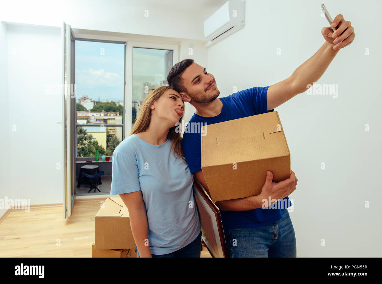 Handsome man make selfie with cell phone while holding cardboard box in ...