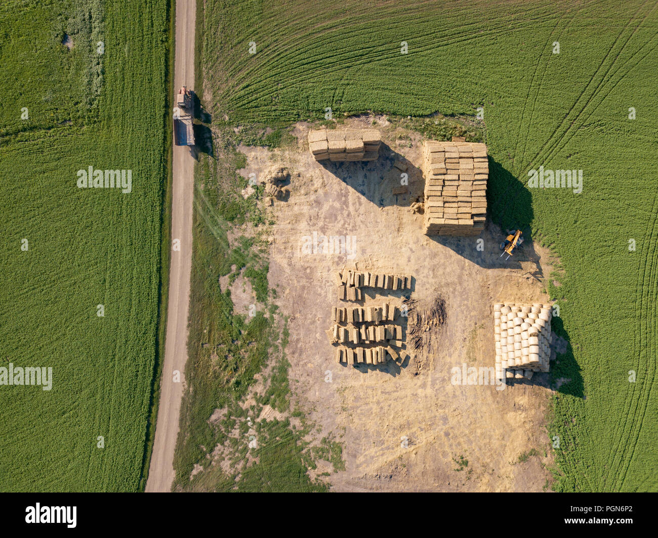 Aerial view from drone into area with stacks of straw after harvesting ...