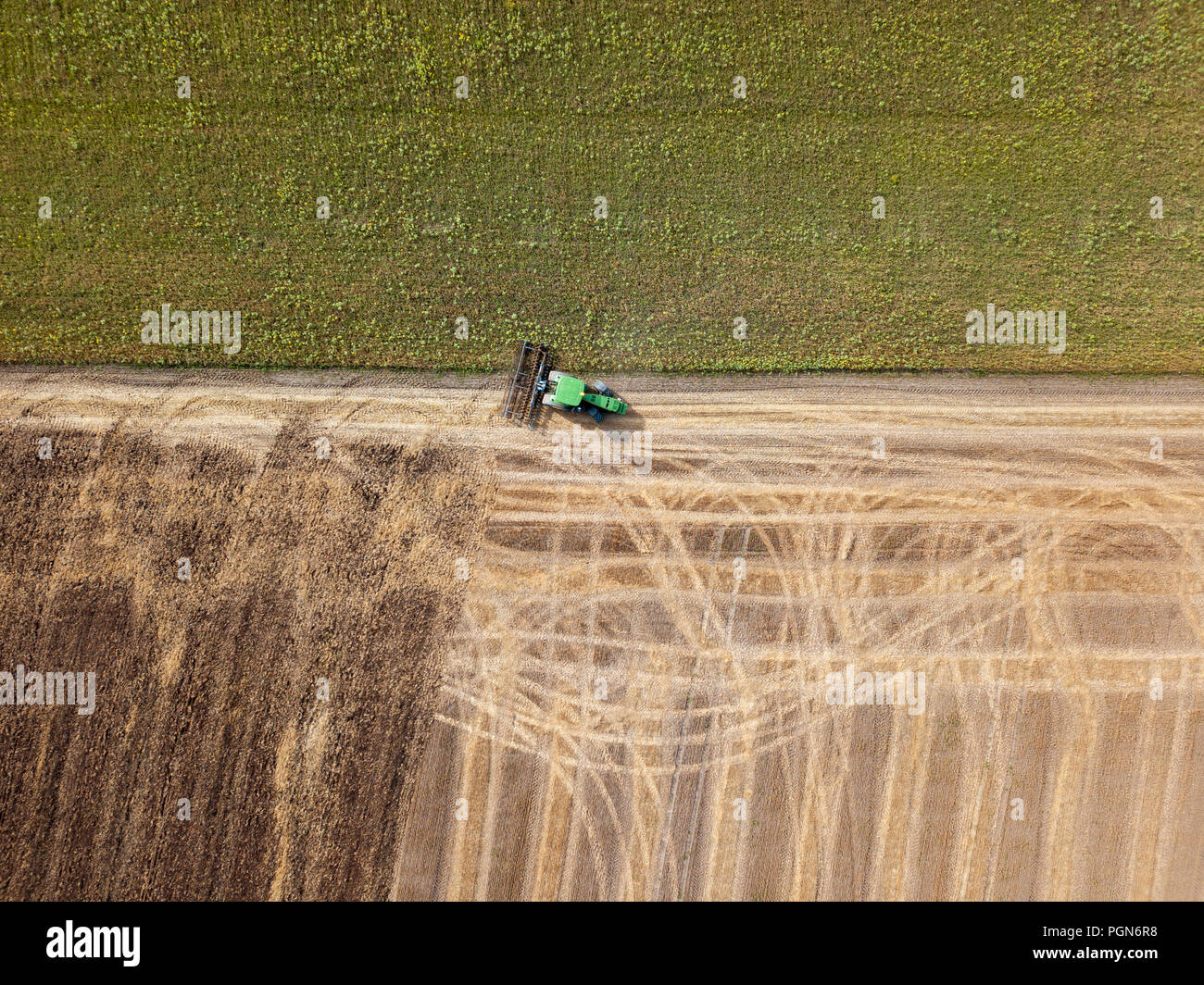 Panoramic view of tractor plowing the soil after harvesting on the ...