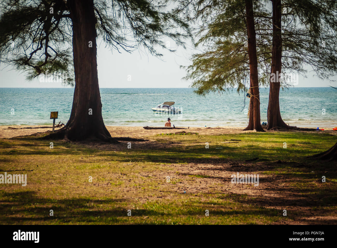 Speed boat moored at shore side, view from forest beach. Seascape view ...