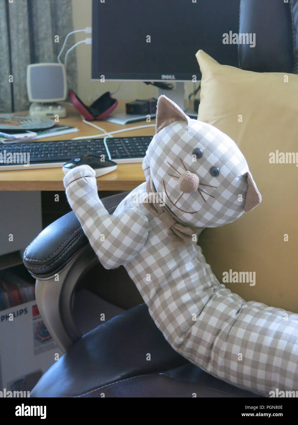 Stuffed toy cat has captured a mouse, her paw is on the computer mouse ...