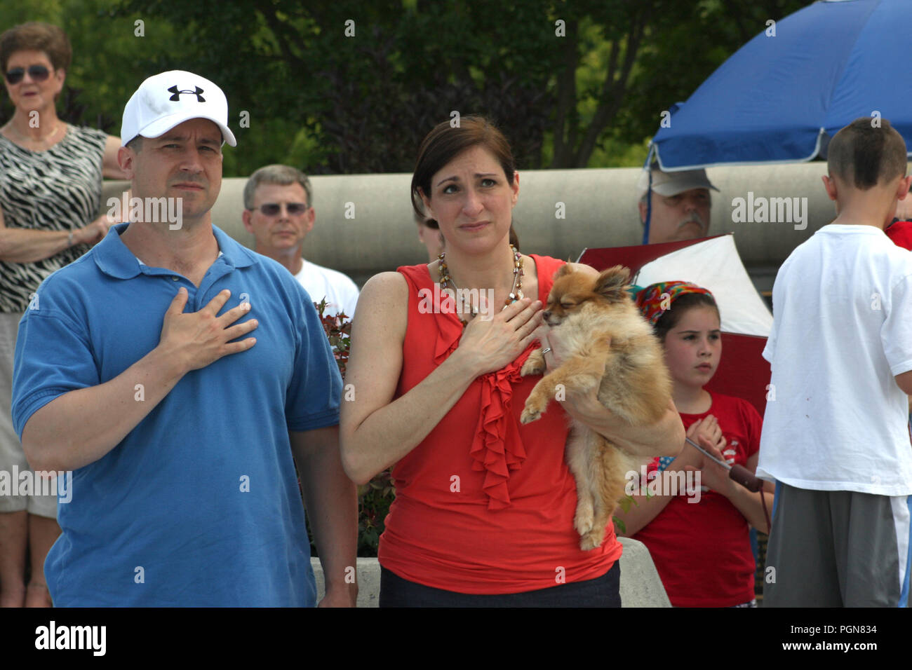 Couple with hand over heart listening to the U.S. National Anthem at ...