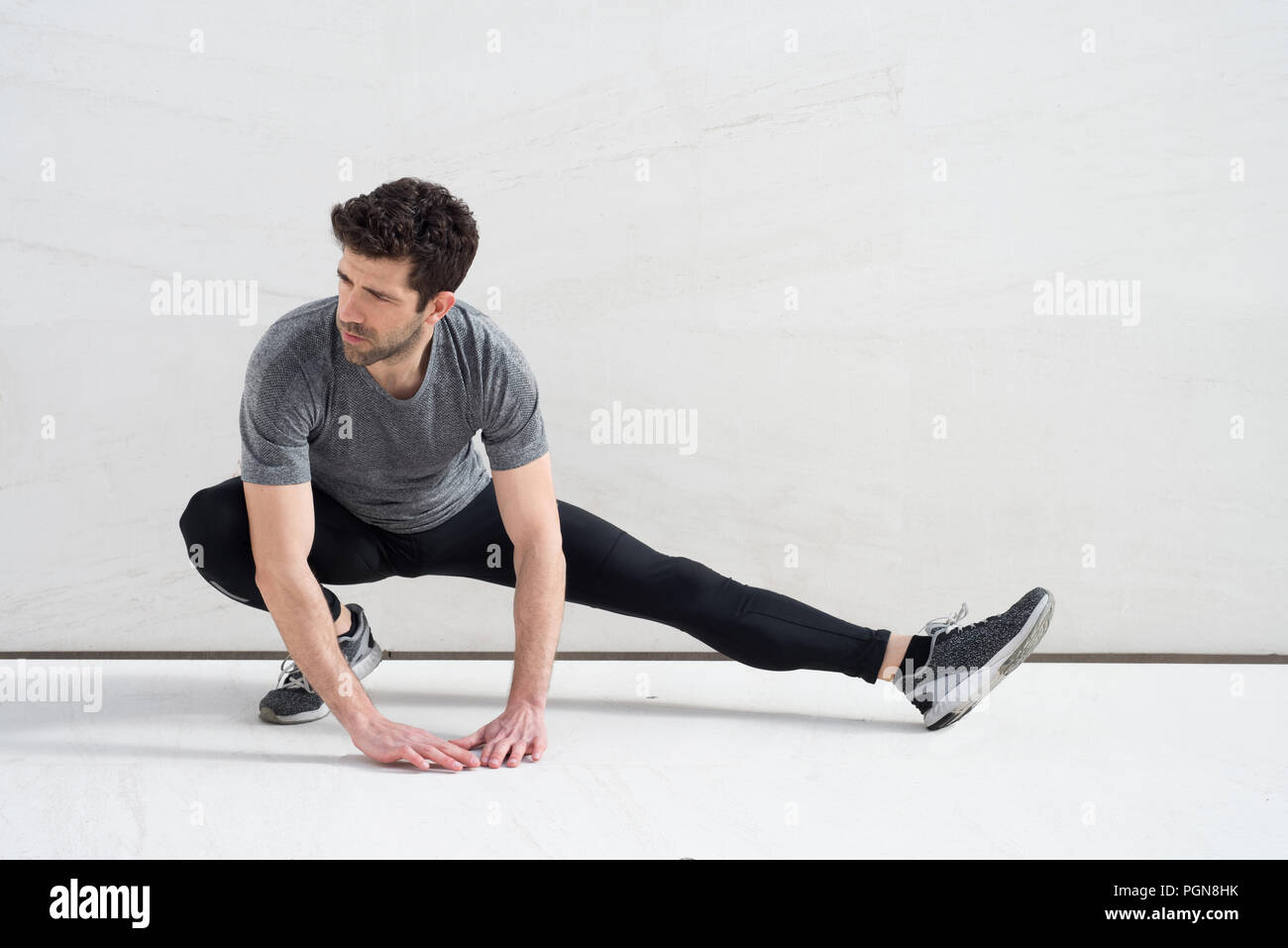 man stretches leg in the ground marble Stock Photo - Alamy