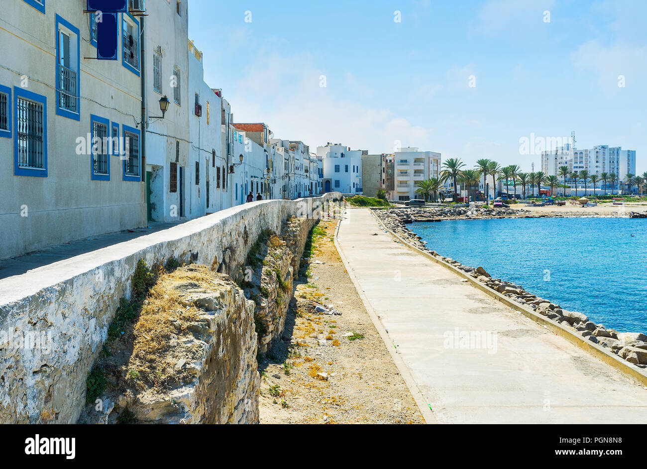 The pleasant walk in shade of houses along the coast of the sea in ...
