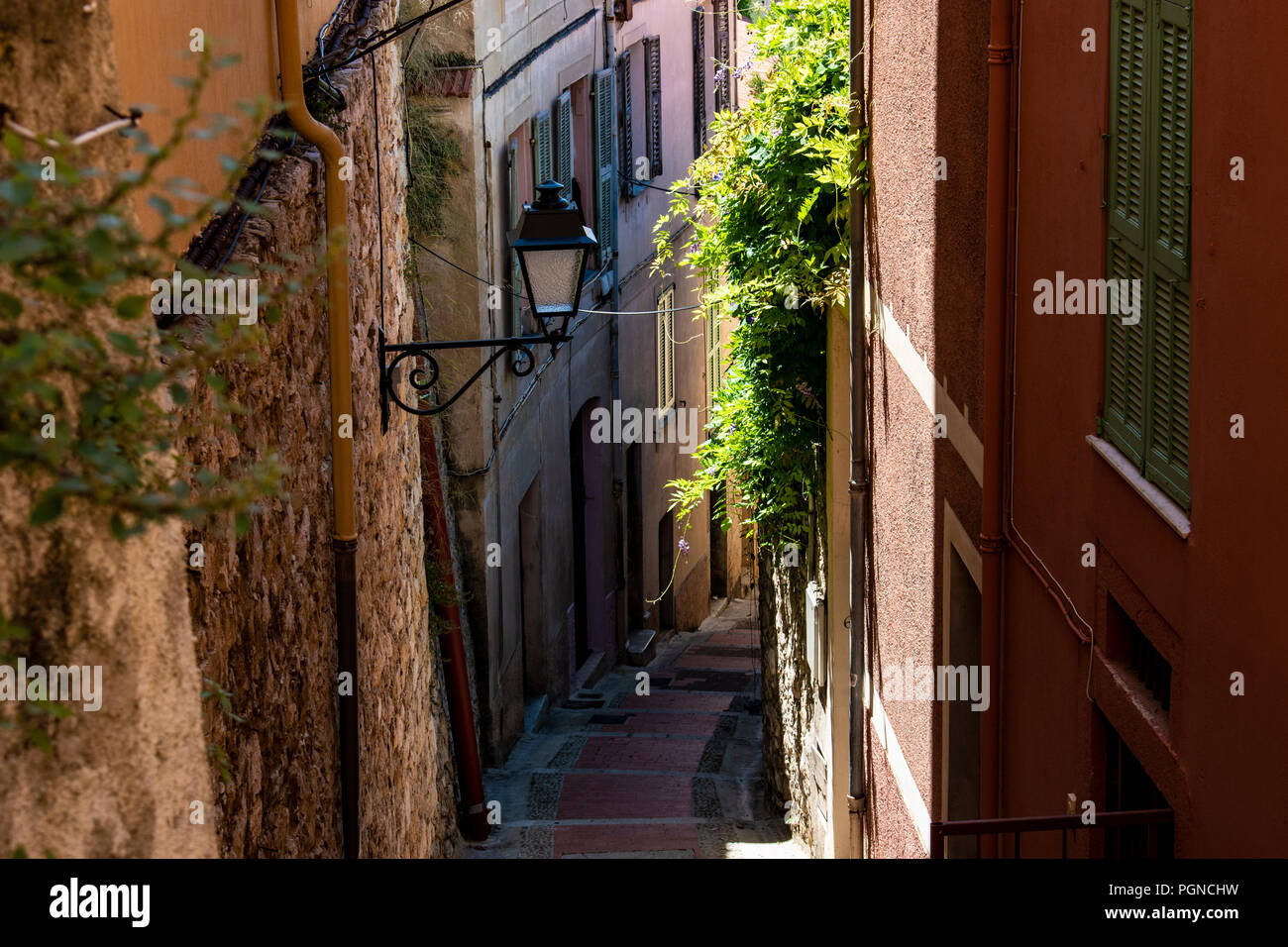 Typical French alley of Menton with flowers and lamp post Stock Photo ...
