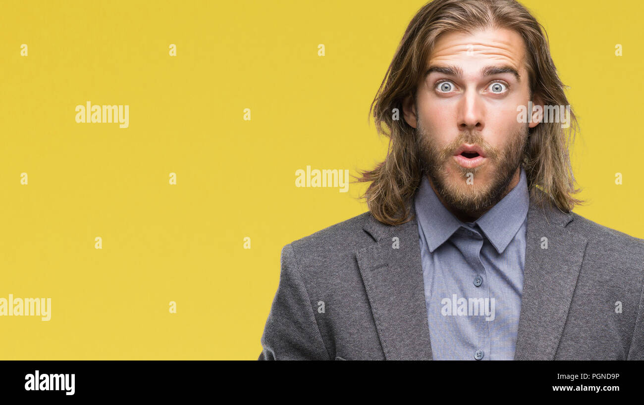 Young handsome business man with long hair over isolated background ...