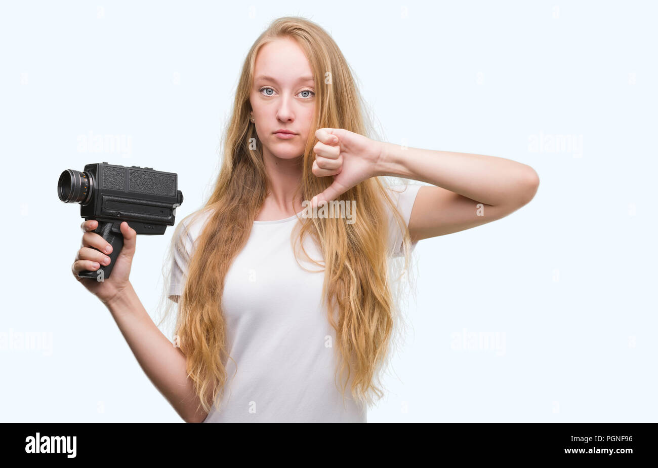 Blonde woman teenager filming holding super 8 video camera with angry ...