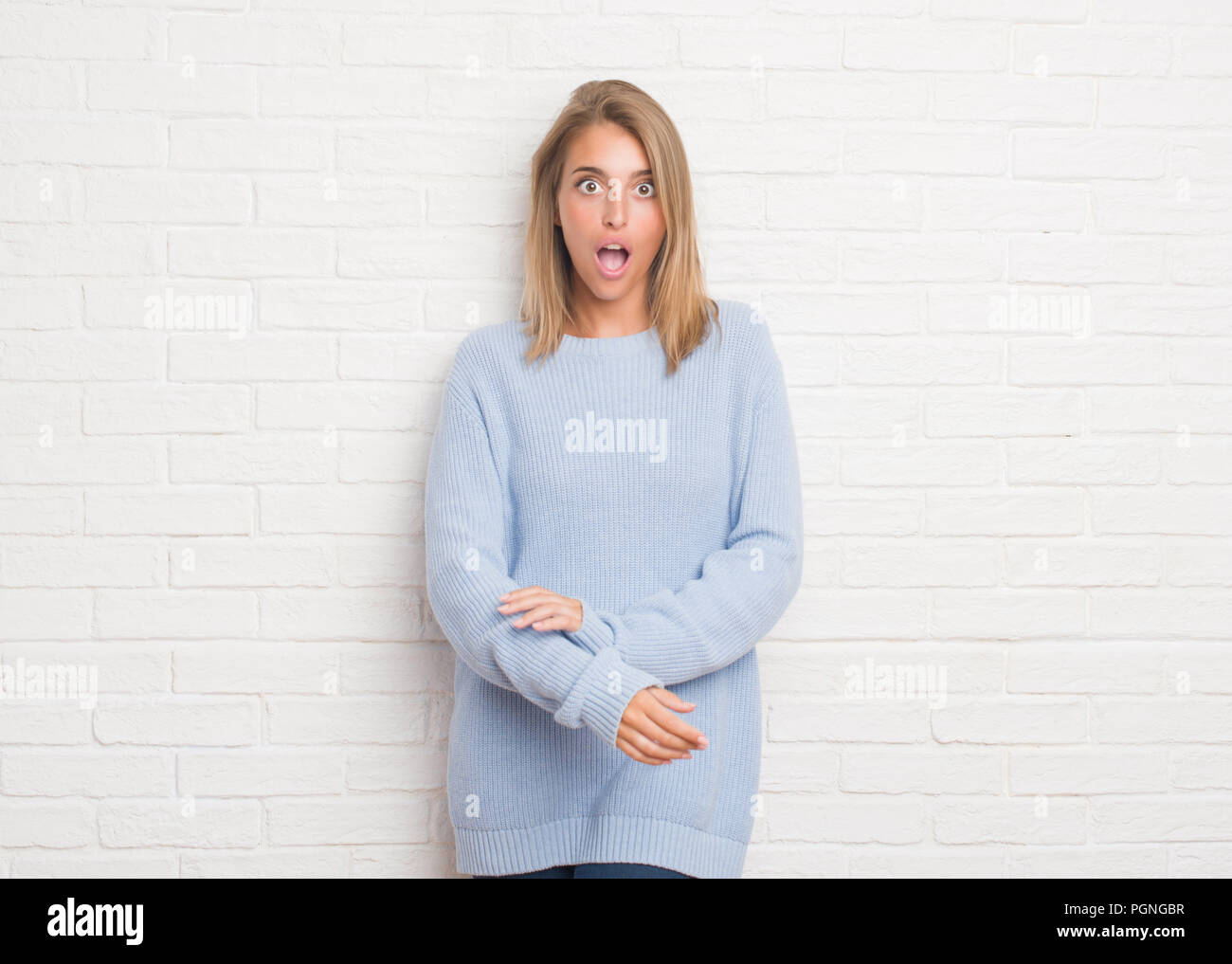 Beautiful Young Woman Over White Brick Wall Afraid And Shocked With