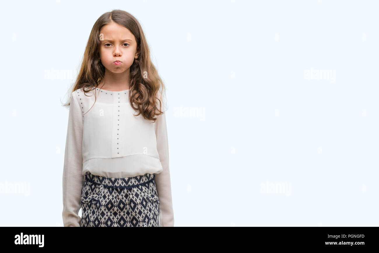 Brunette hispanic girl puffing cheeks with funny face. Mouth inflated ...