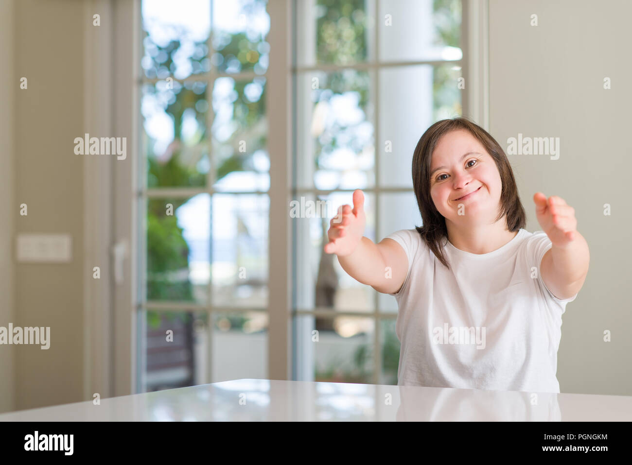 Down syndrome woman at home looking at the camera smiling with open ...
