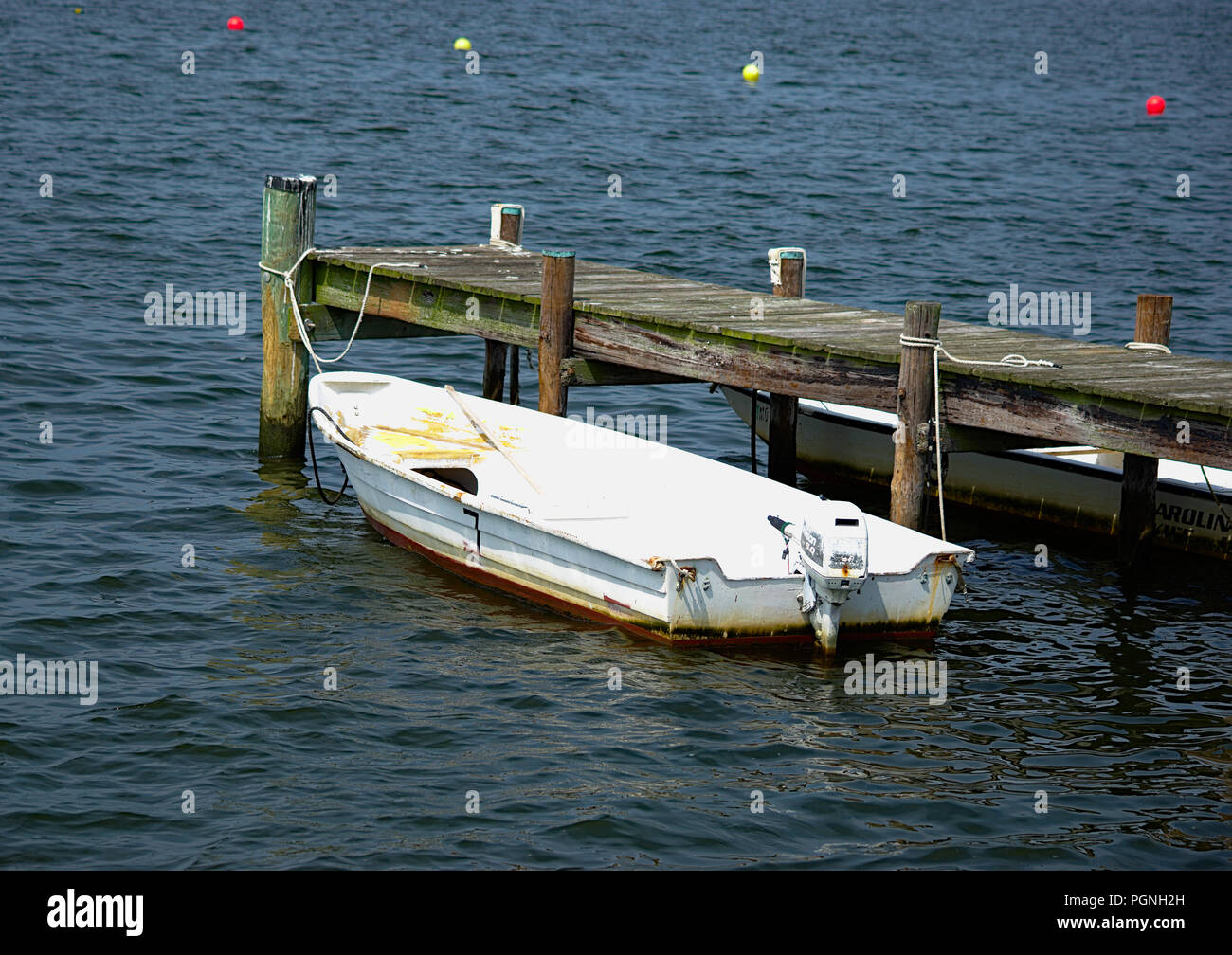 small boat with engine tied to dock Stock Photo - Alamy