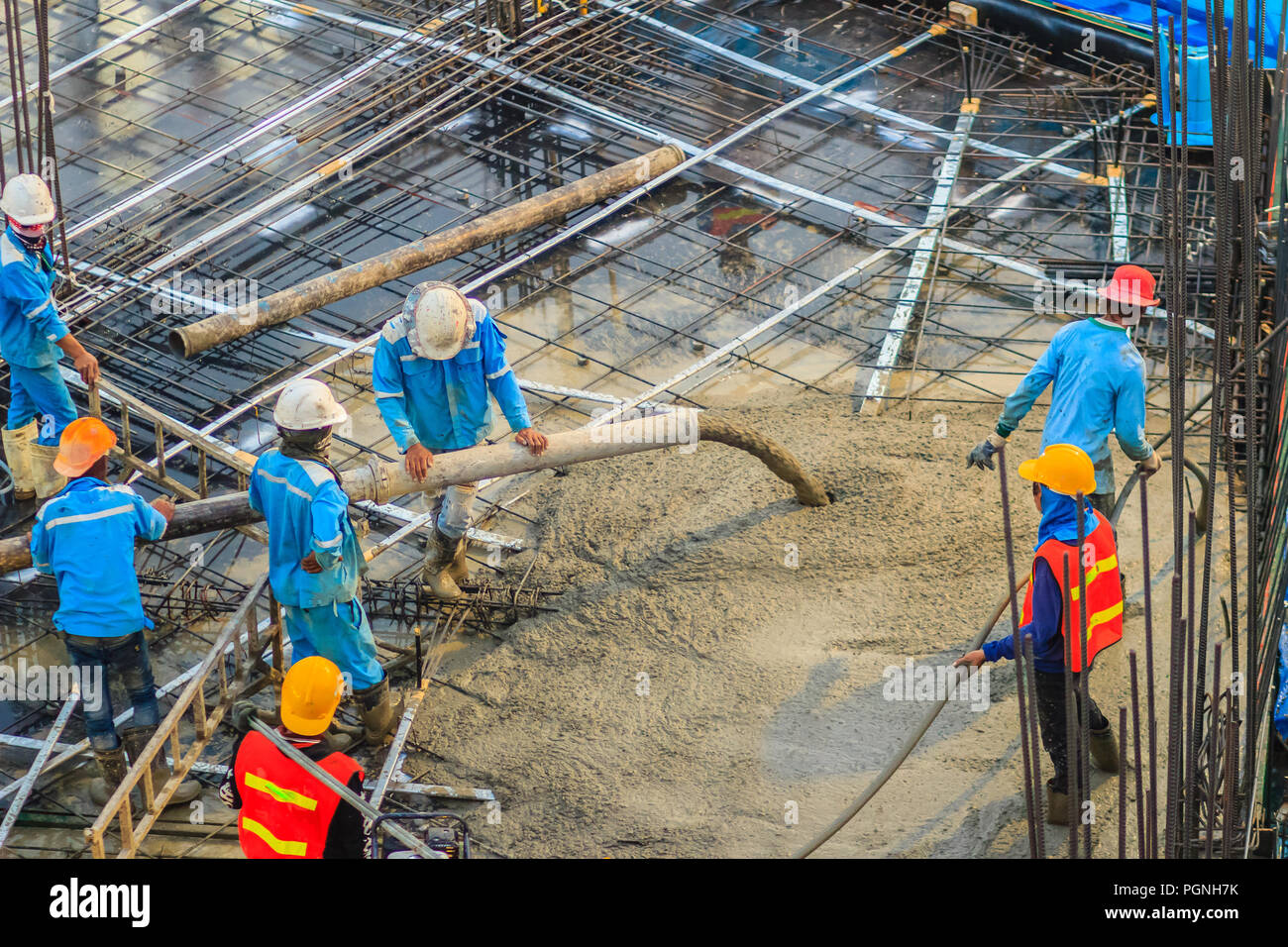 Construction workers are pouring concrete in post-tension flooring work ...
