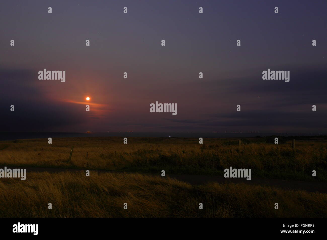 An Orange moon makes an appearance on a cloudy night sky at Flamborough ...