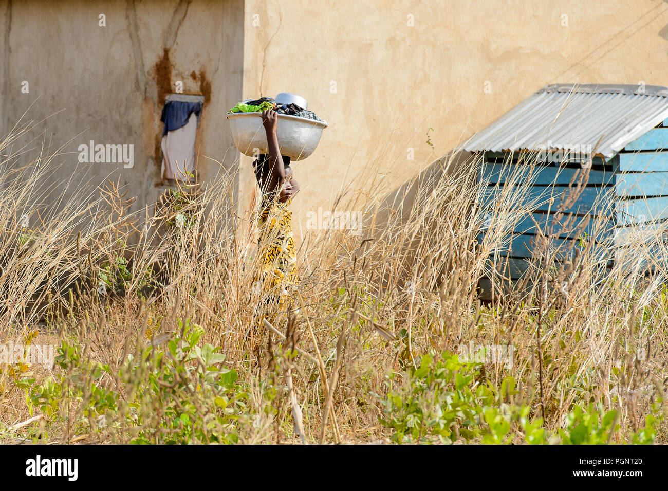 GHANI, GHANA - JAN 14, 2017: Unidentified Ghanaian girl carries a basin ...