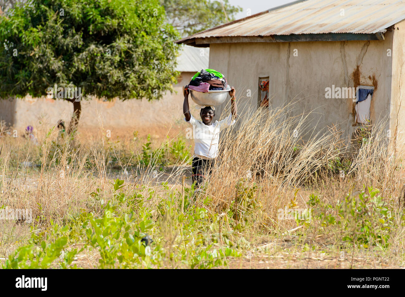 GHANI, GHANA - JAN 14, 2017: Unidentified Ghanaian boy carries a basin ...