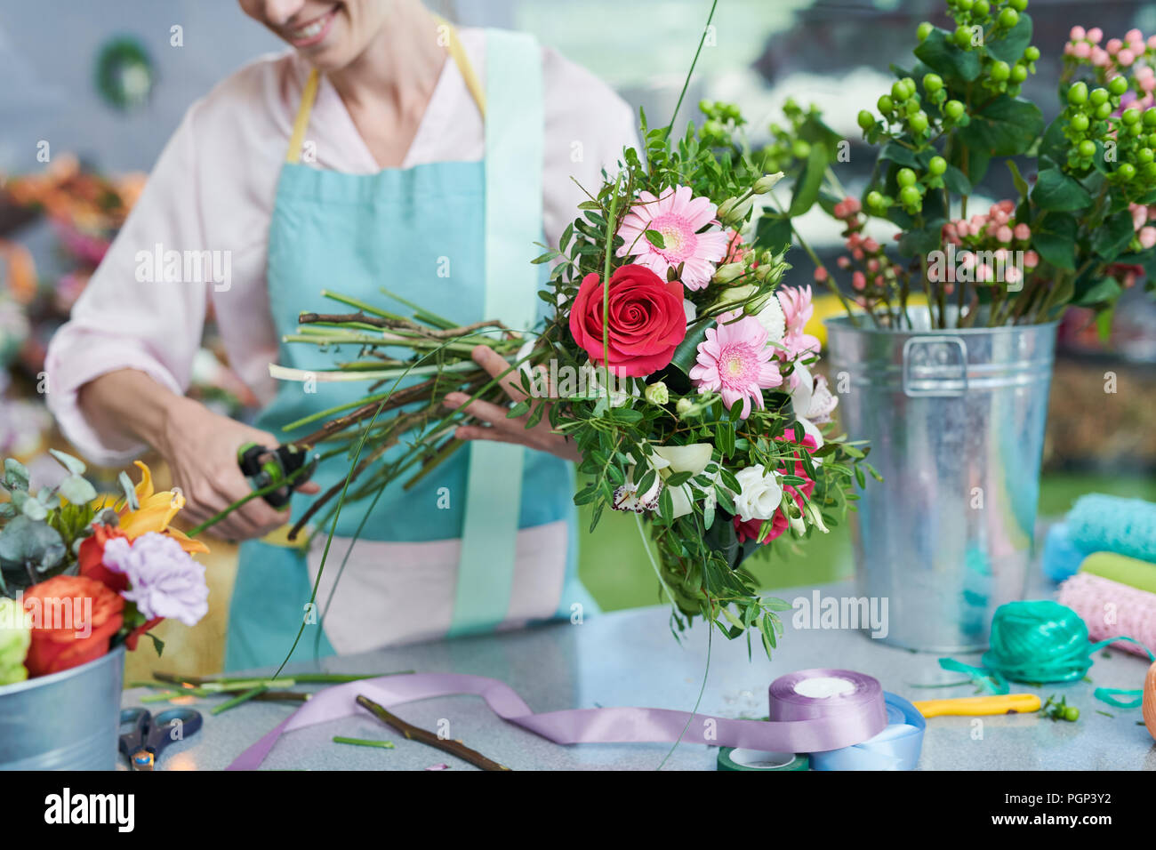 Crop view of smiling florist snipping flower stems Stock Photo - Alamy