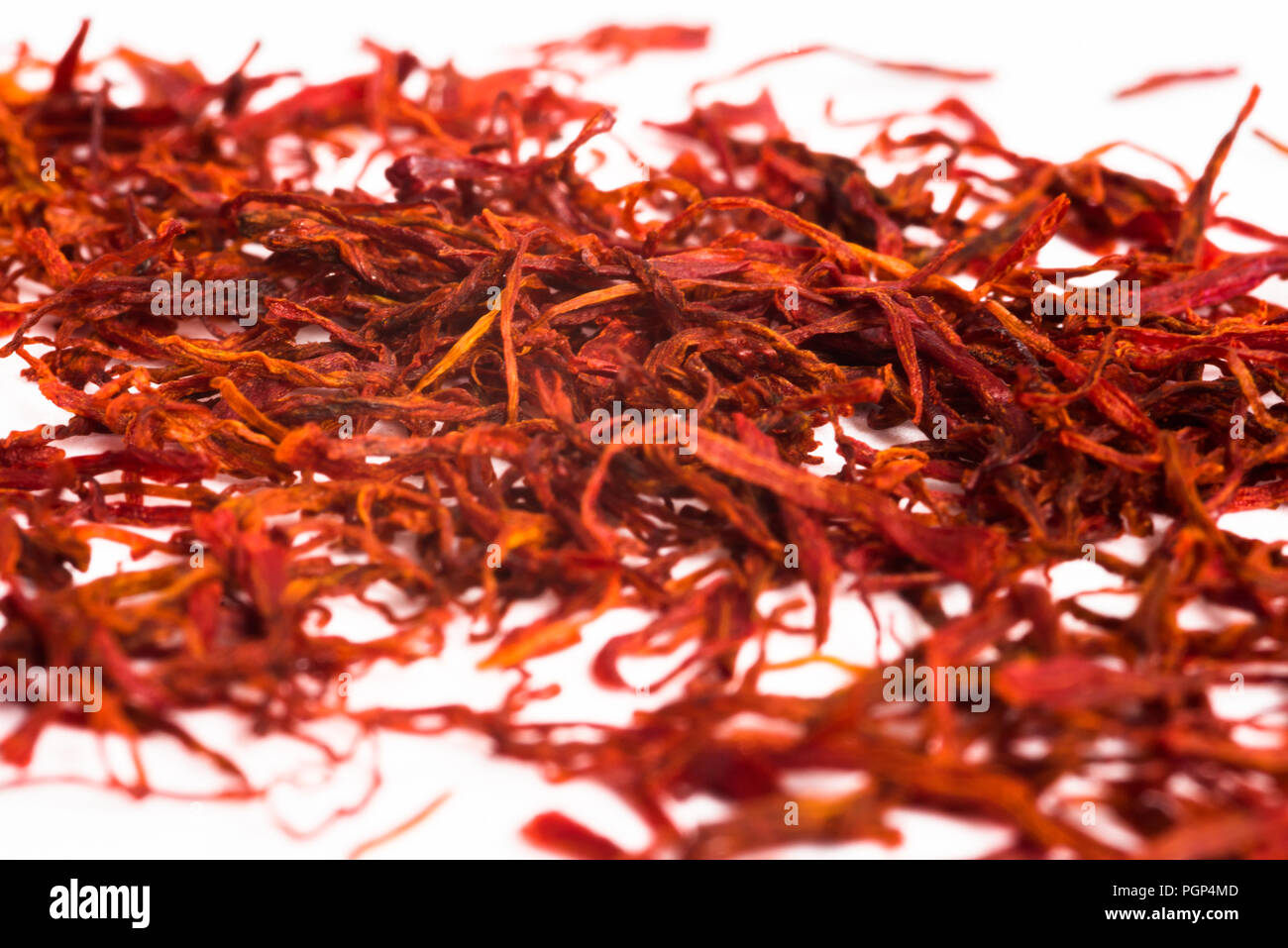 Saffron threads shown in detail on a white background Stock Photo - Alamy