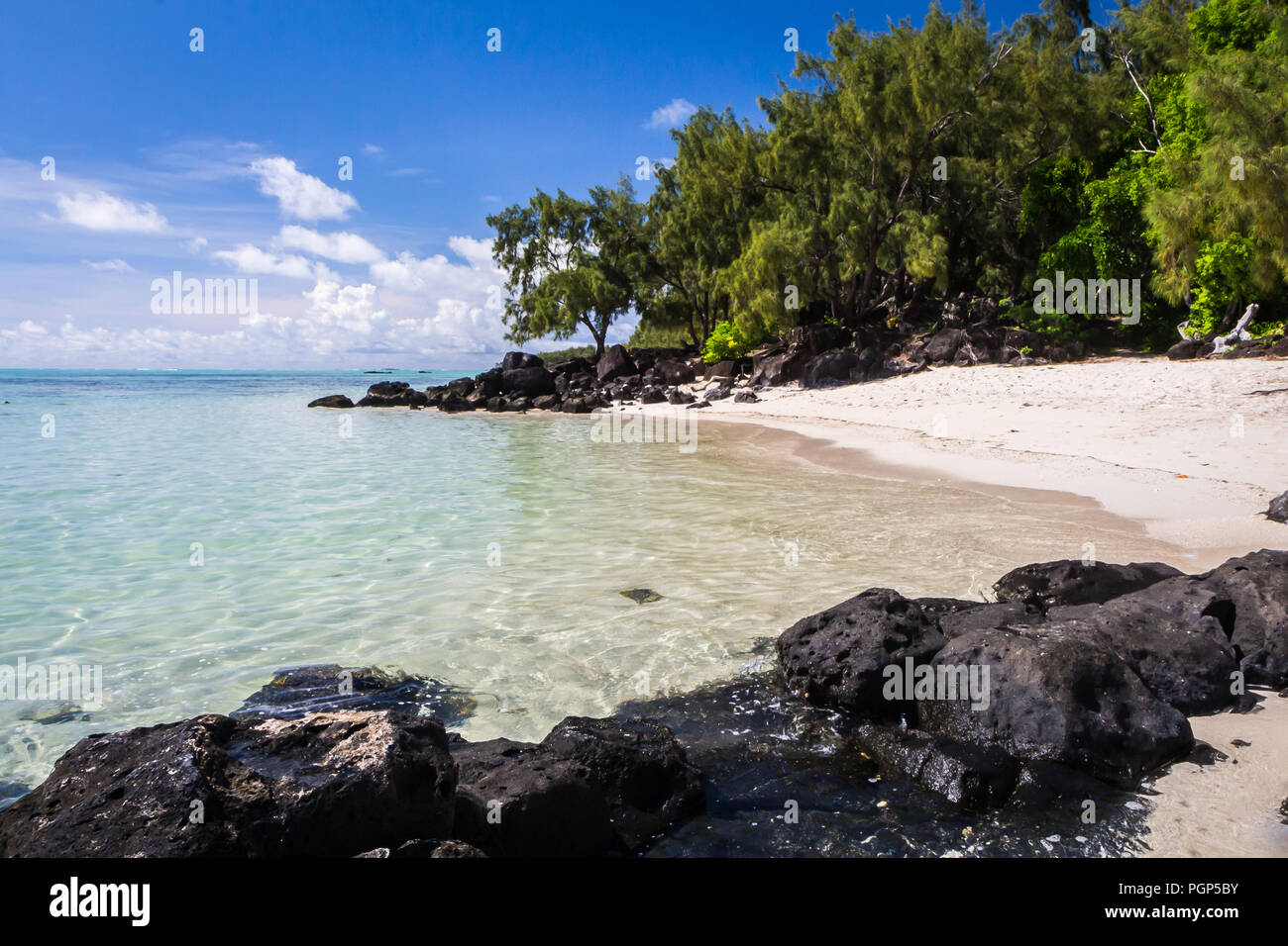 blue ocean and black lava stones on a sandy beach of volcanic island ...